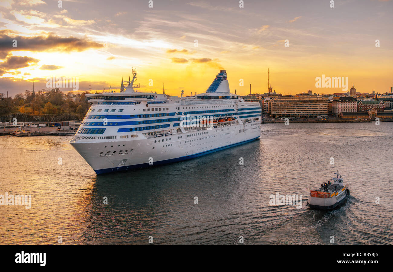 Passenger ferry and tugboat sail against Helsinki city in South Harbour ...