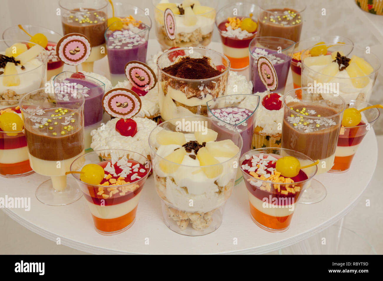 Different fruit desserts with fruits in glasses on the table ...