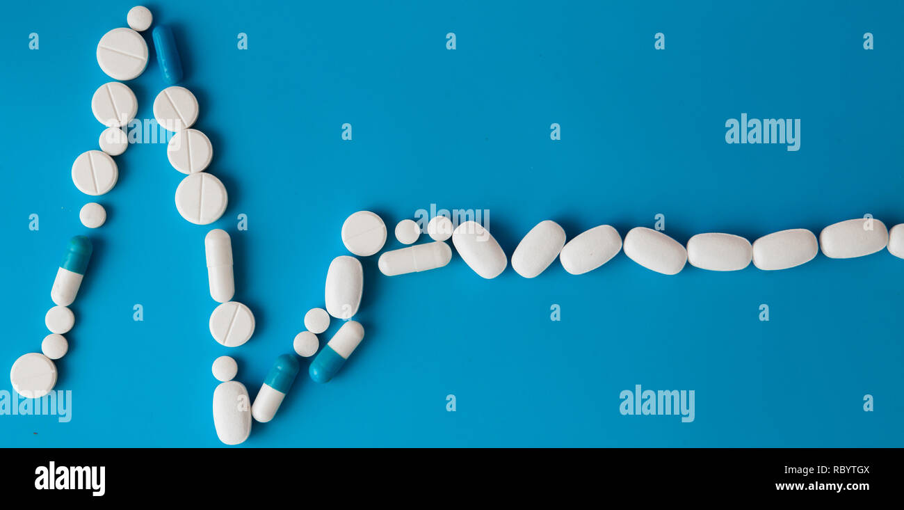 Medicines white, round heart shaped pills isolated on blue background ...