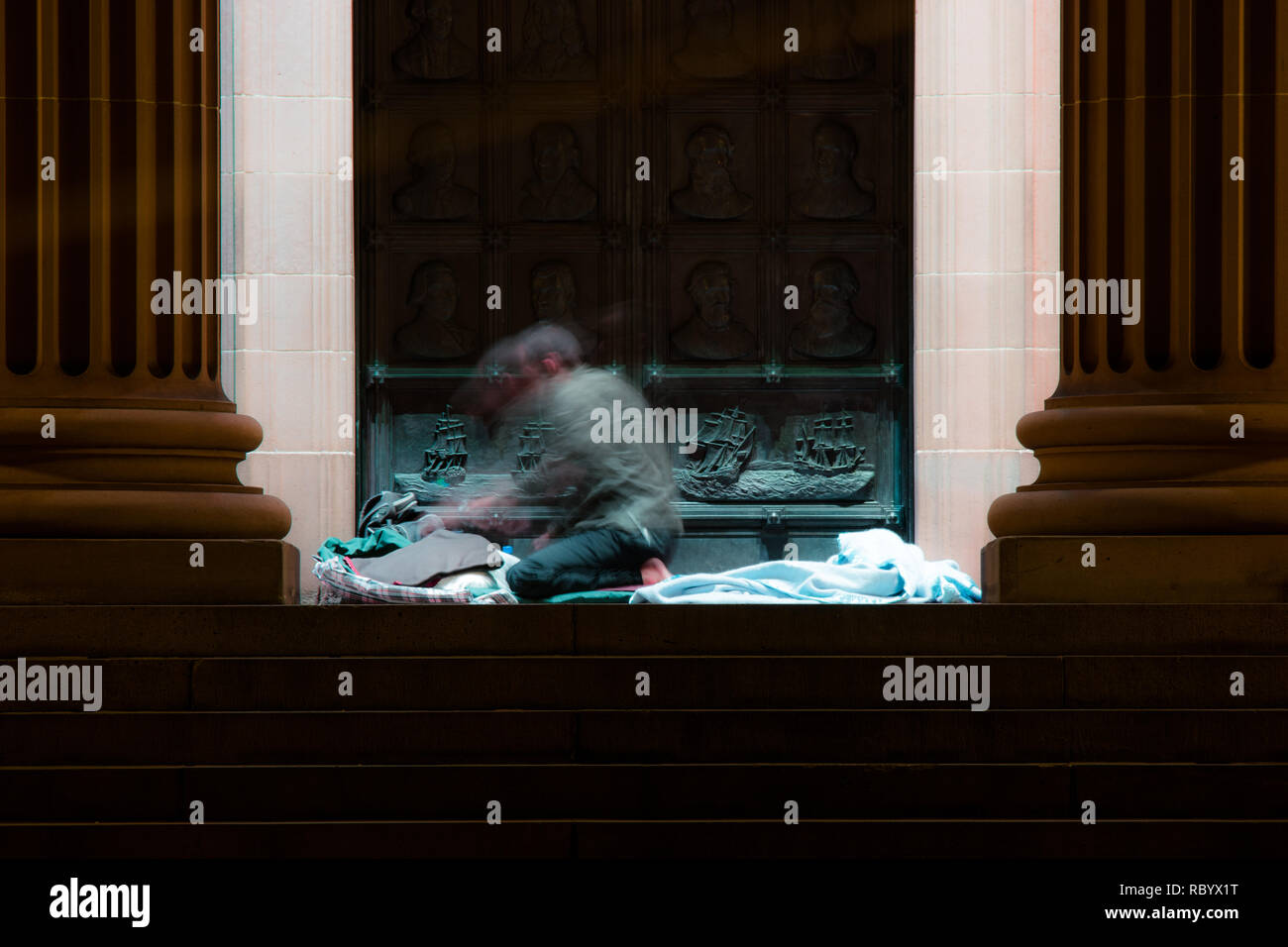 a homeless man wakes early in the morning on the steps of a library ...