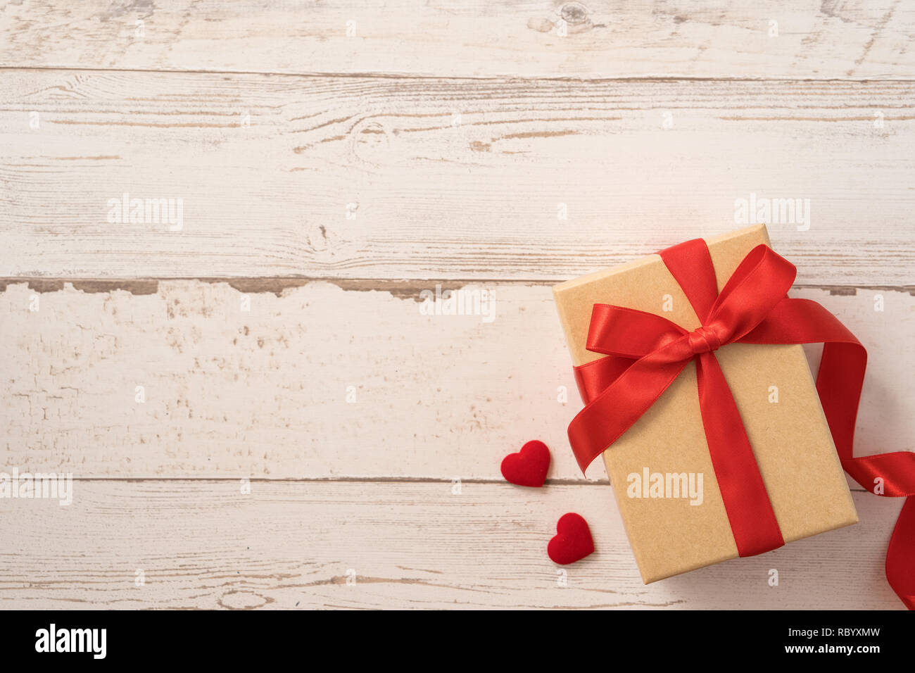 Kraft gift box with red ribbon bow, concept of giving present and ...