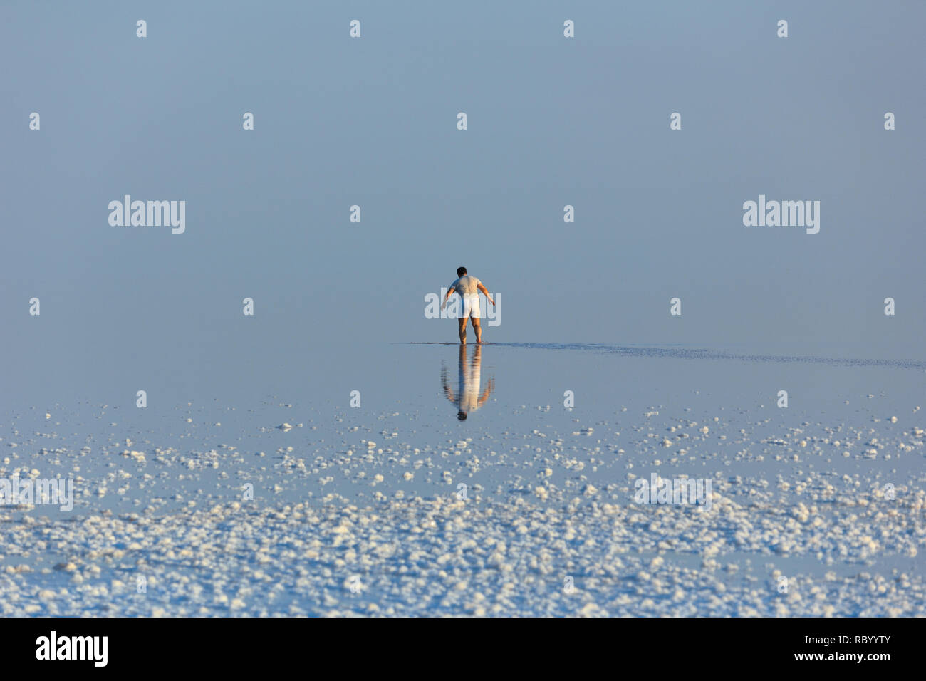 A man walking alone on salt flat of Urmia Lake, West Azerbaijan ...