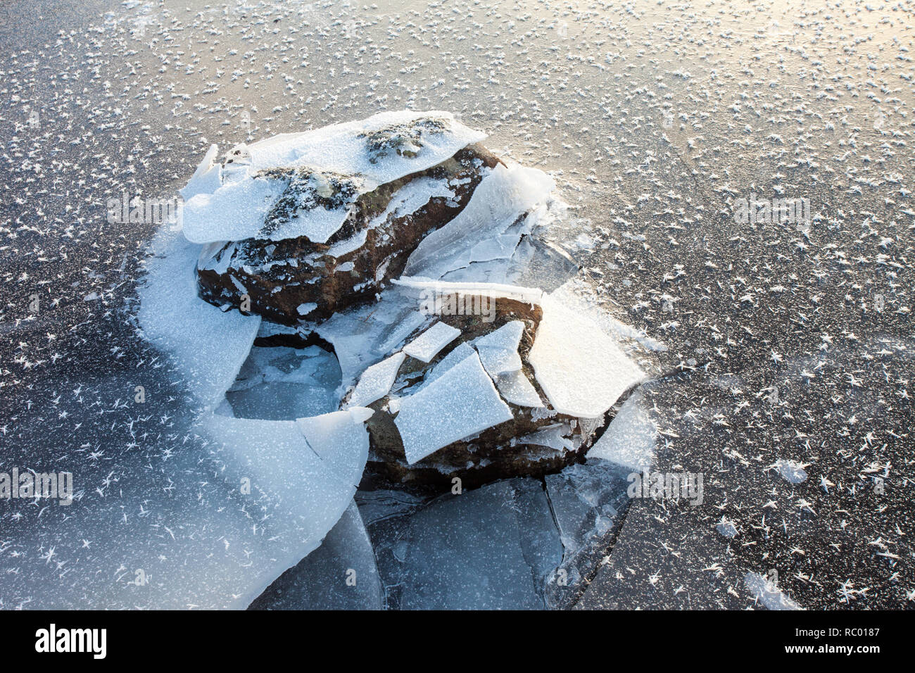 Frozen lake close up, with rock breaking the ice UK Stock Photo - Alamy