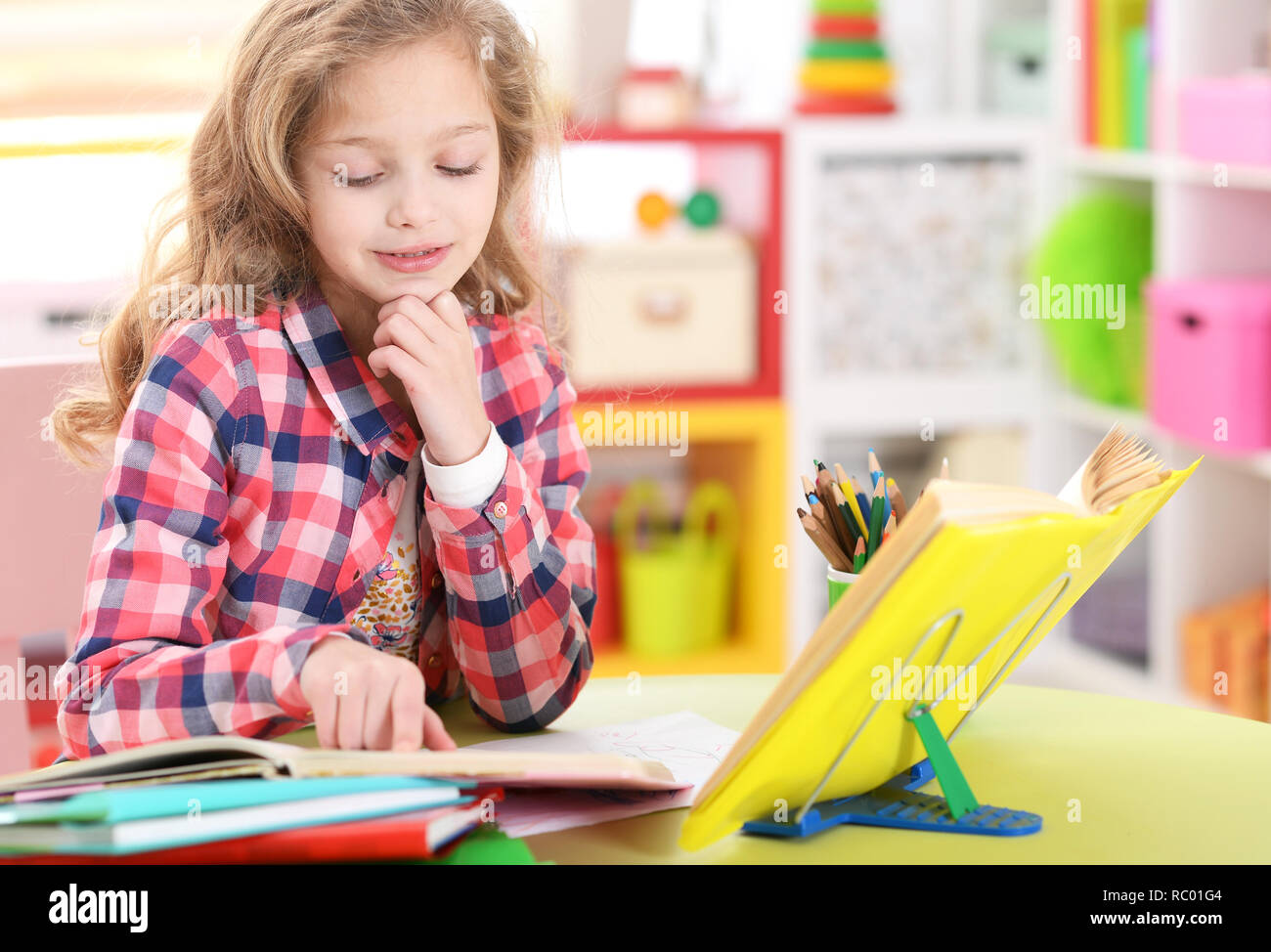 Portrait of cute little girl doing homework Stock Photo - Alamy