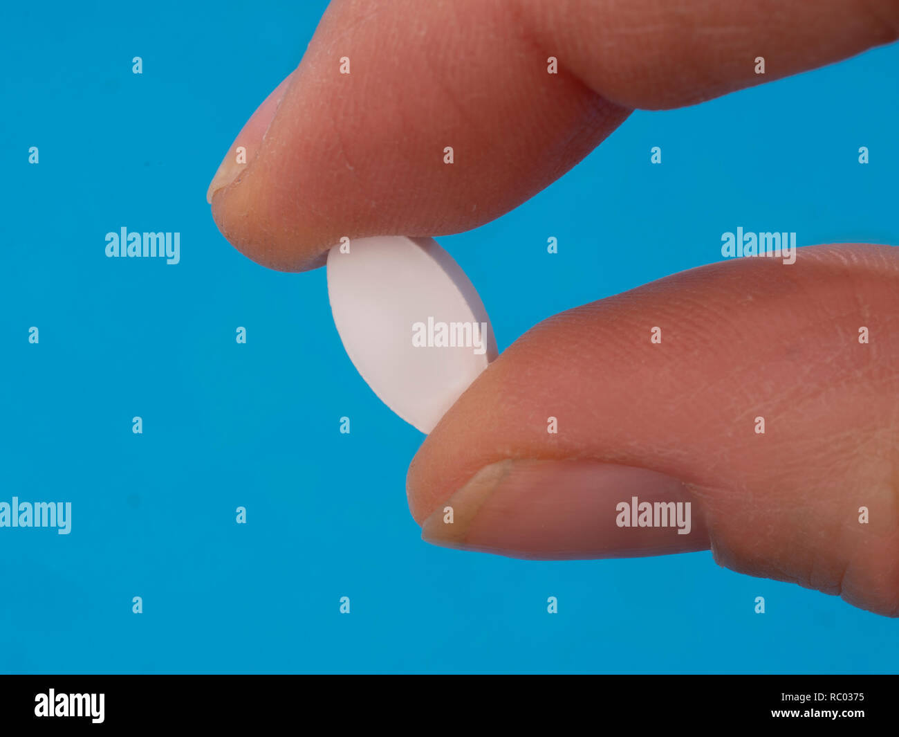 Alendronate sodium tablet between fingers, a nonhormonal medication for ...