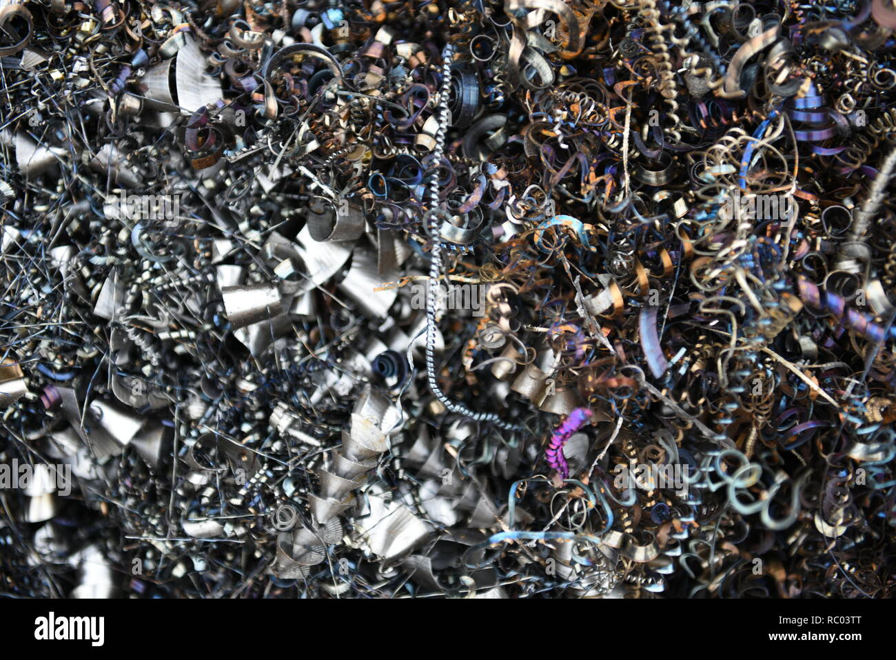 Tangled twisted pile of colorful discarded industrial scrap metal waste ...