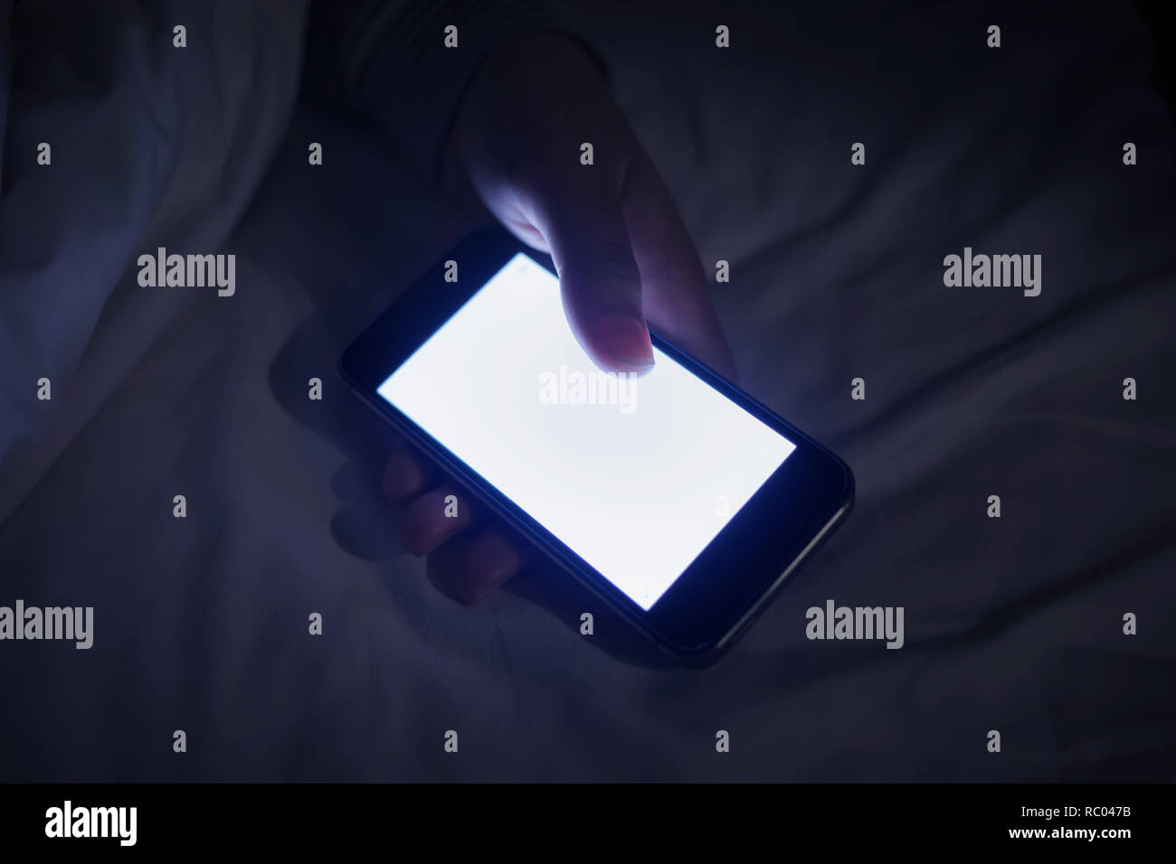 Female using smartphone on her bed in night time Stock Photo - Alamy