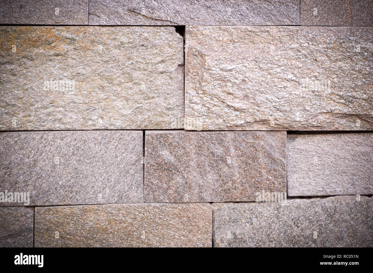 beige weathered stone tiled wall background with vignette. texture ...