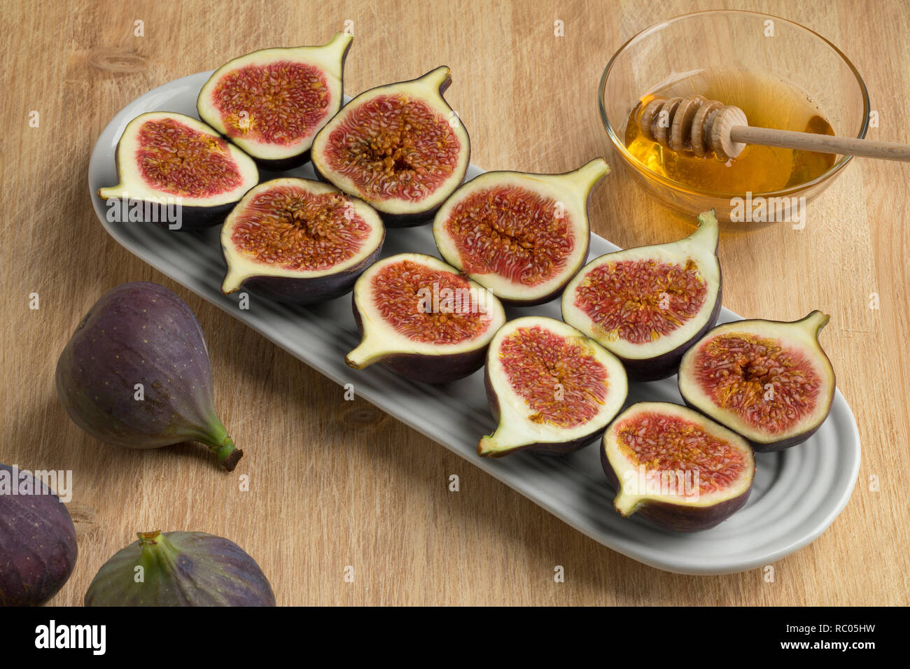 Fresh ripe half figs and honey for dessert Stock Photo - Alamy