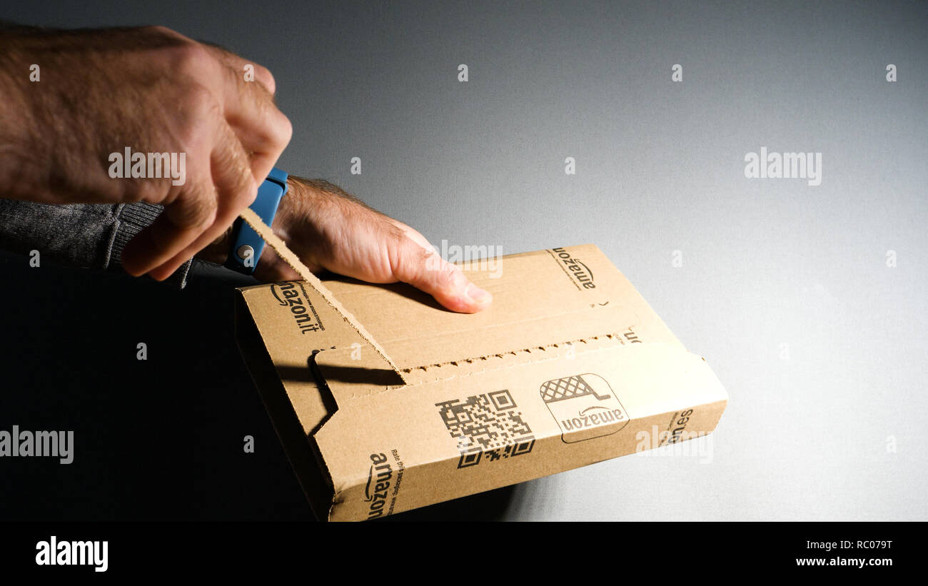 PARIS, FRANCE - FEB 7, 2018: Man pull carton box unboxing Amazon prime ...