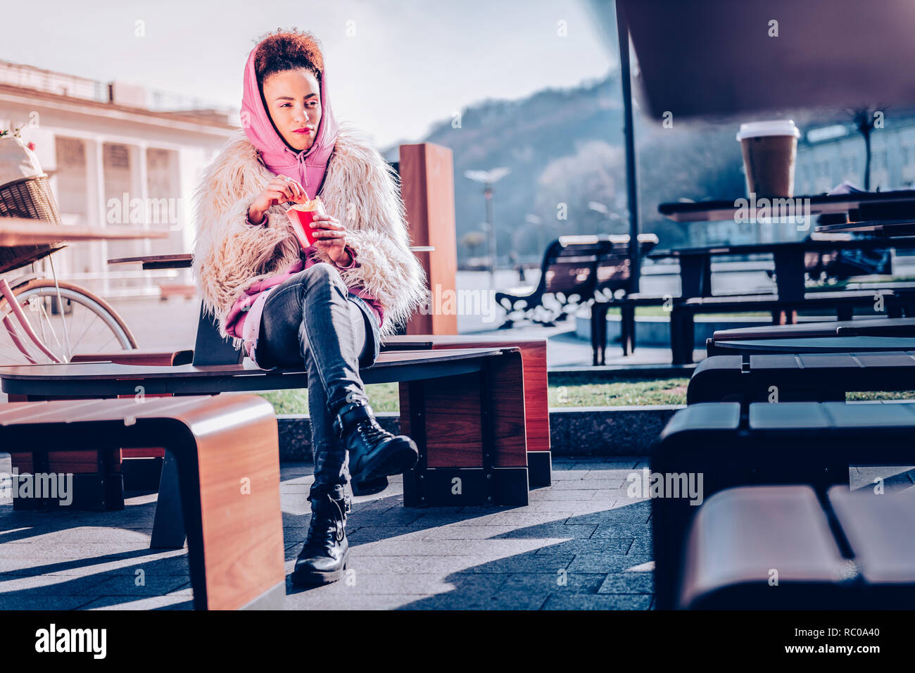Attentive international girl eating fast food in cafe Stock Photo - Alamy