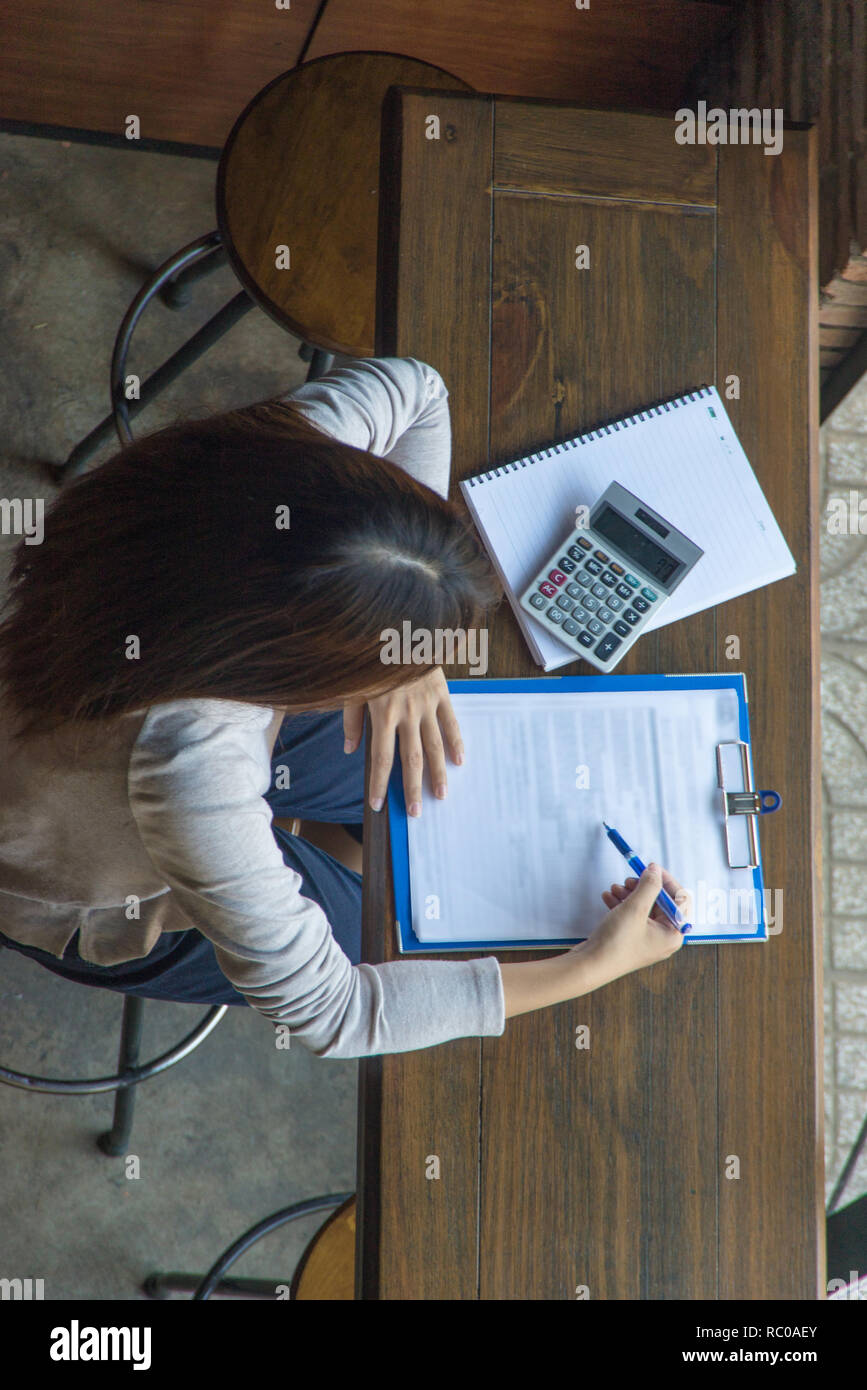 Female student doing homework at library Stock Photo - Alamy