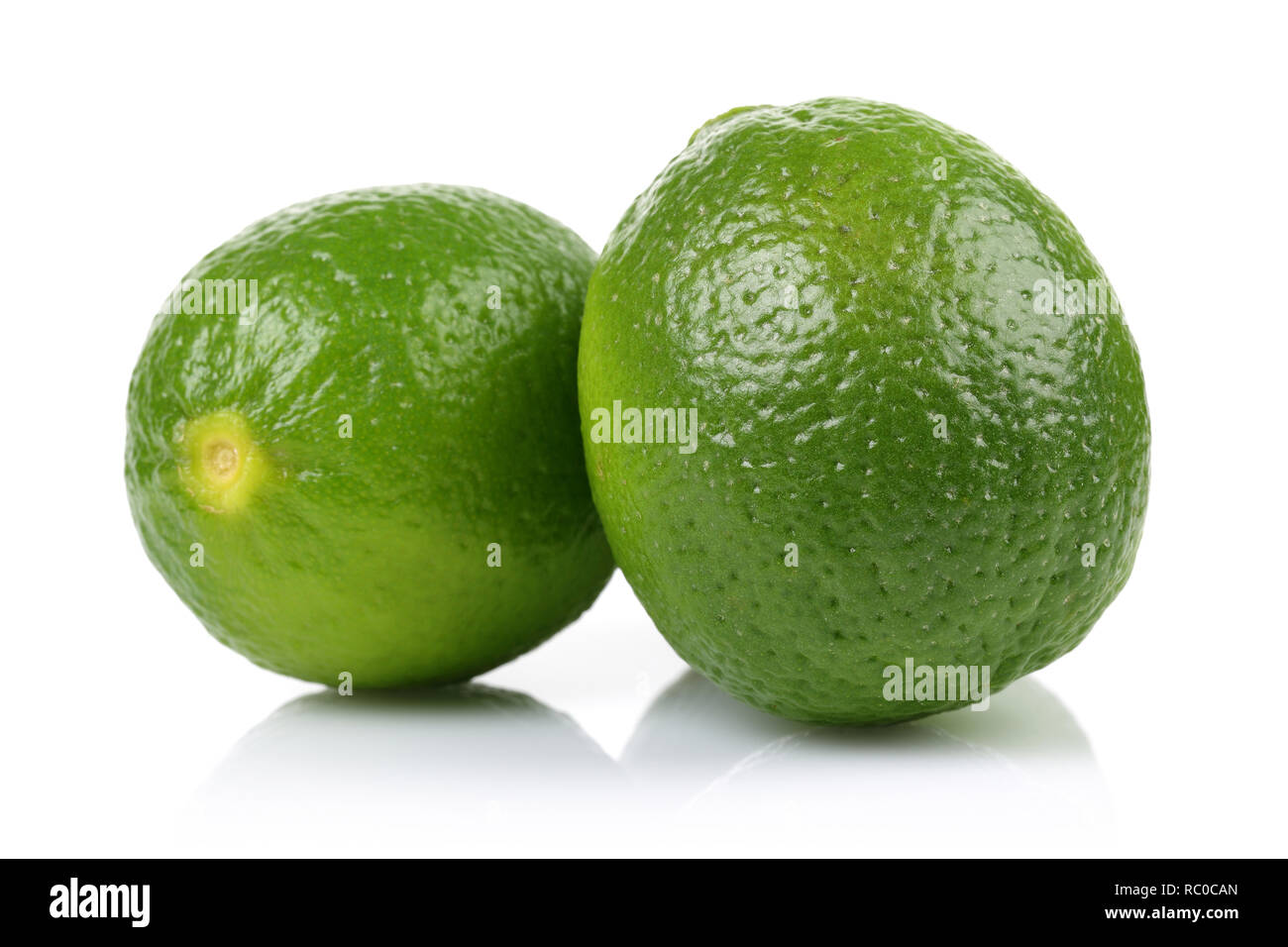 Two green lime isolated on white background Stock Photo - Alamy