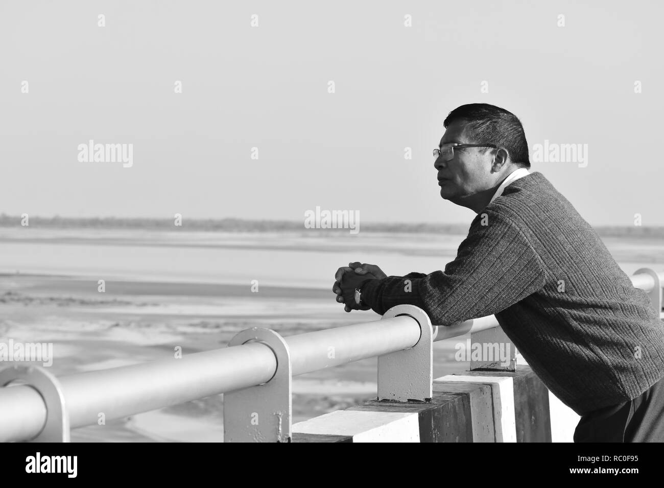 A man standing on a bridge and looking around Stock Photo - Alamy