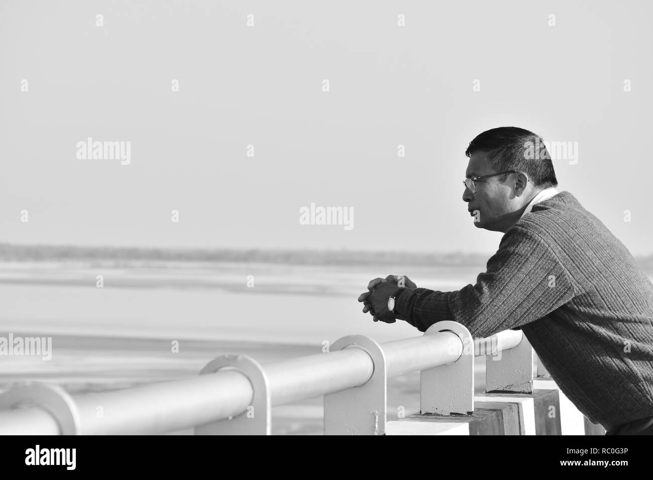 A man standing on a bridge and looking around Stock Photo - Alamy