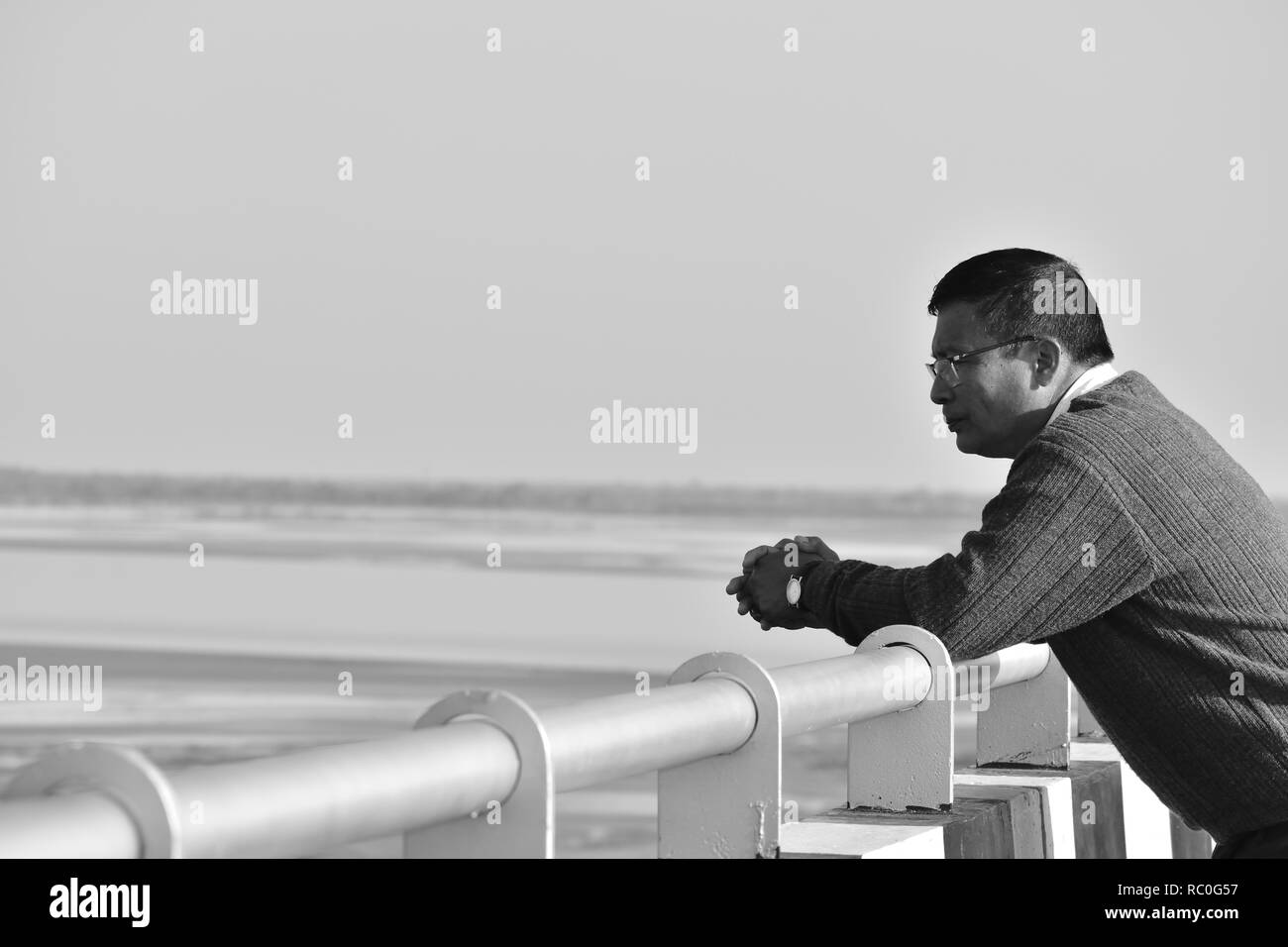 A man standing on a bridge and looking around Stock Photo - Alamy