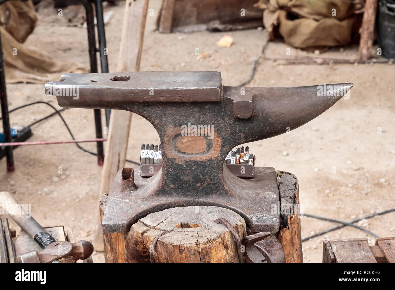 horizontal view of an outdoor scene with an old anvil on foreground ...