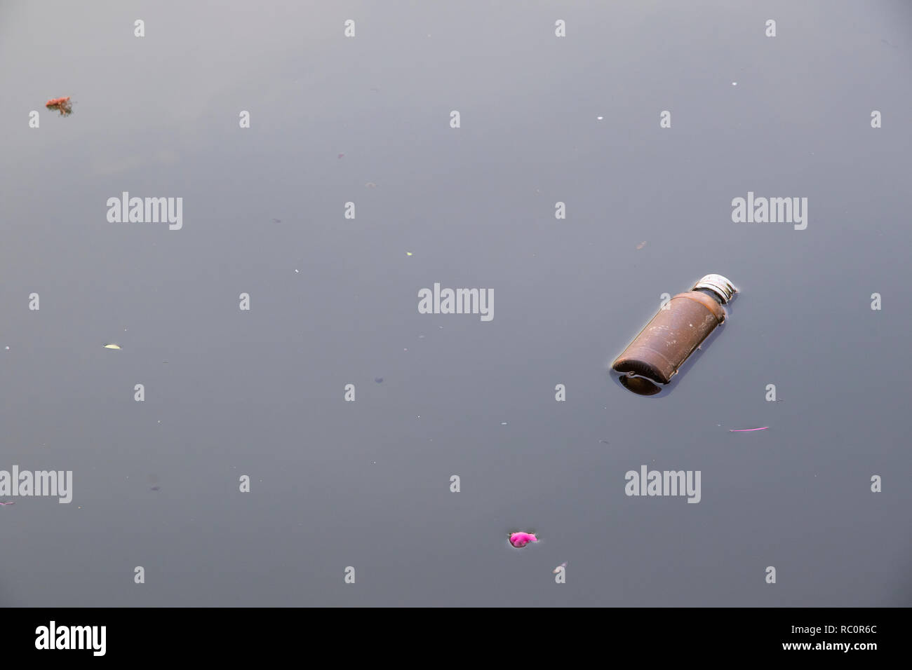 Rusty bottles floating in the waste water background Stock Photo - Alamy