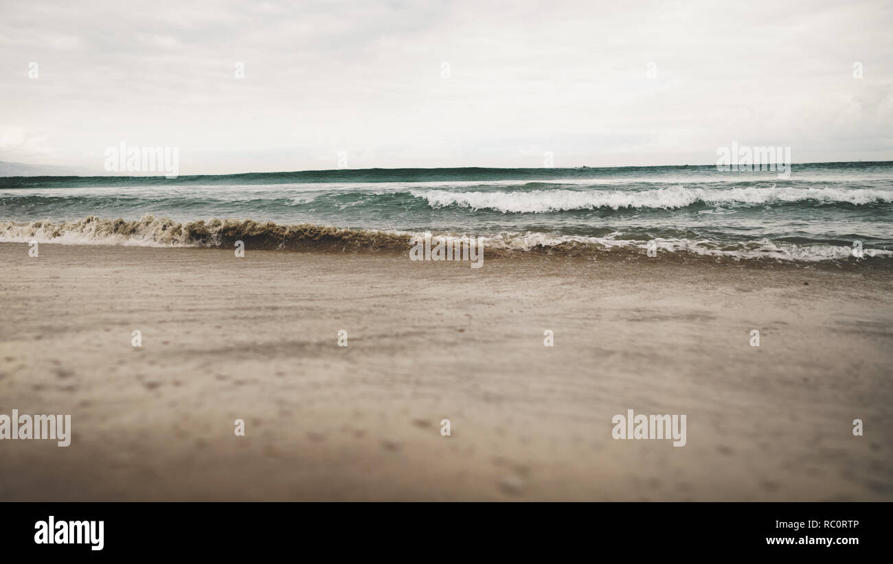 ocean waves on beach in cloudy day, travel photo Stock Photo - Alamy