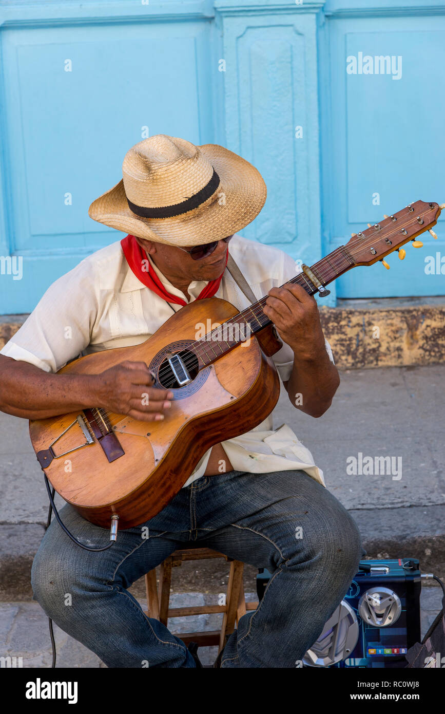 Old Cuban musician playing acoustic guitar solo on a street corner in ...