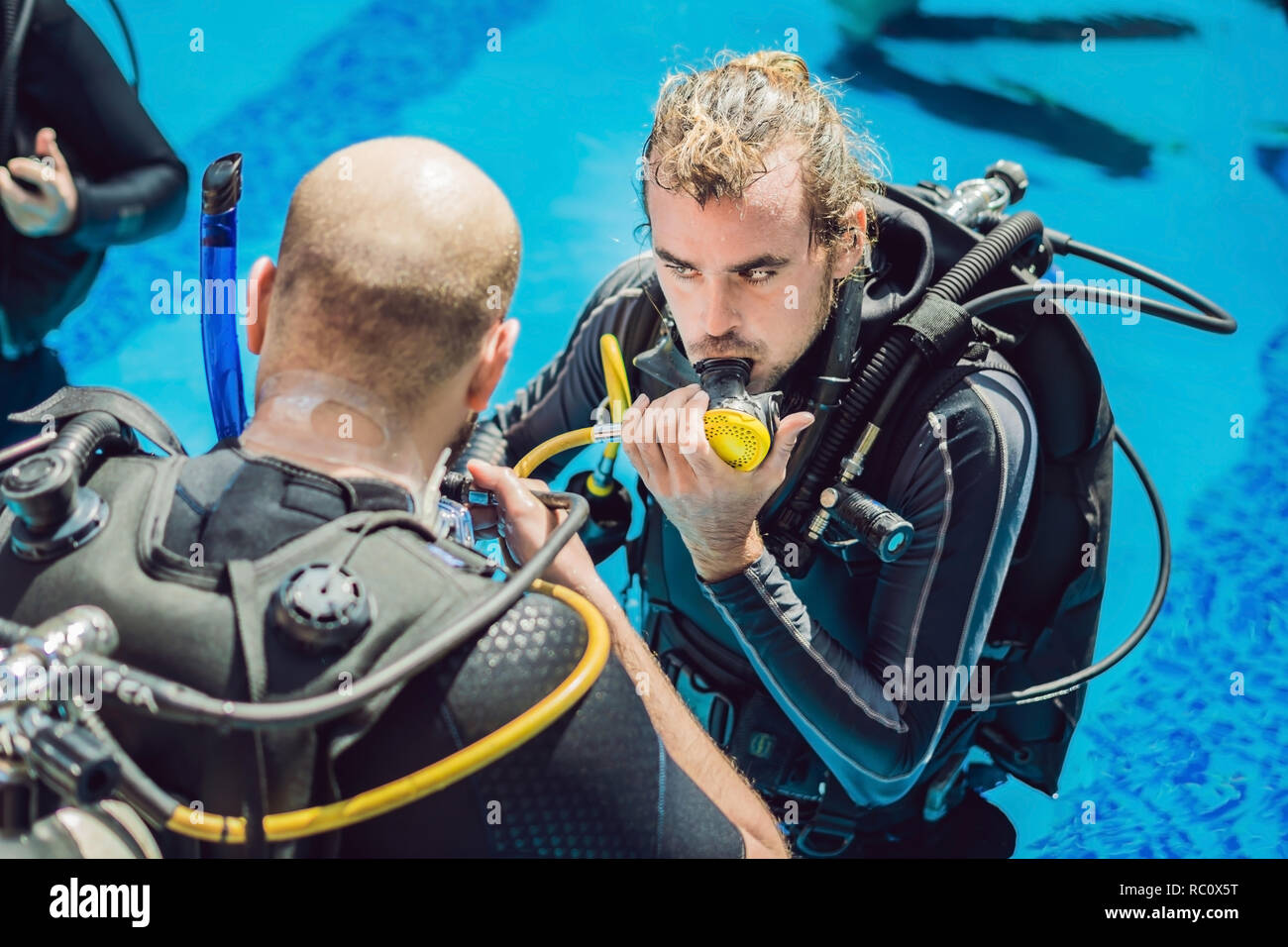 Diving instructor and students. Instructor teaches students to dive ...