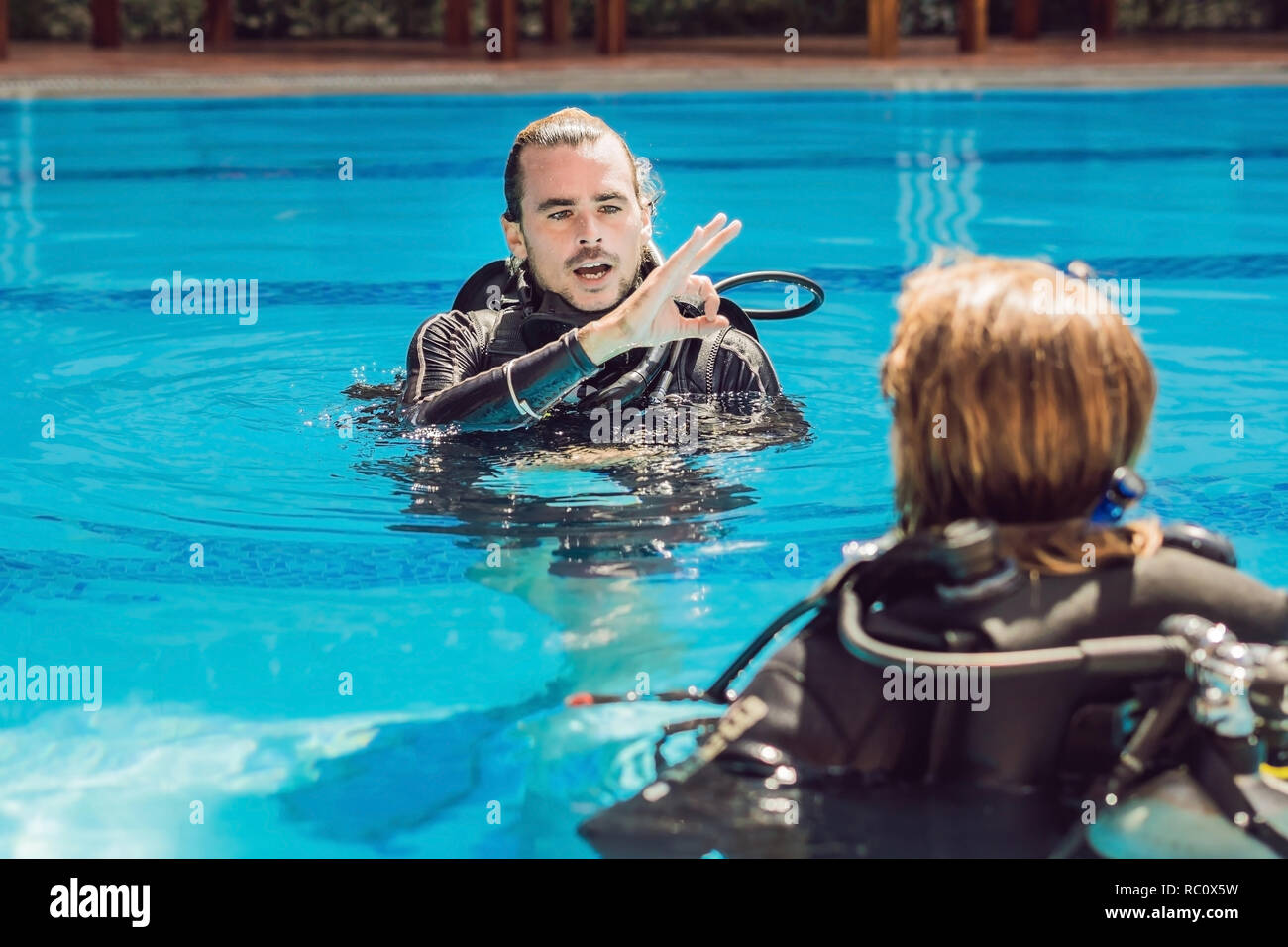 Diving instructor and students. Instructor teaches students to dive ...