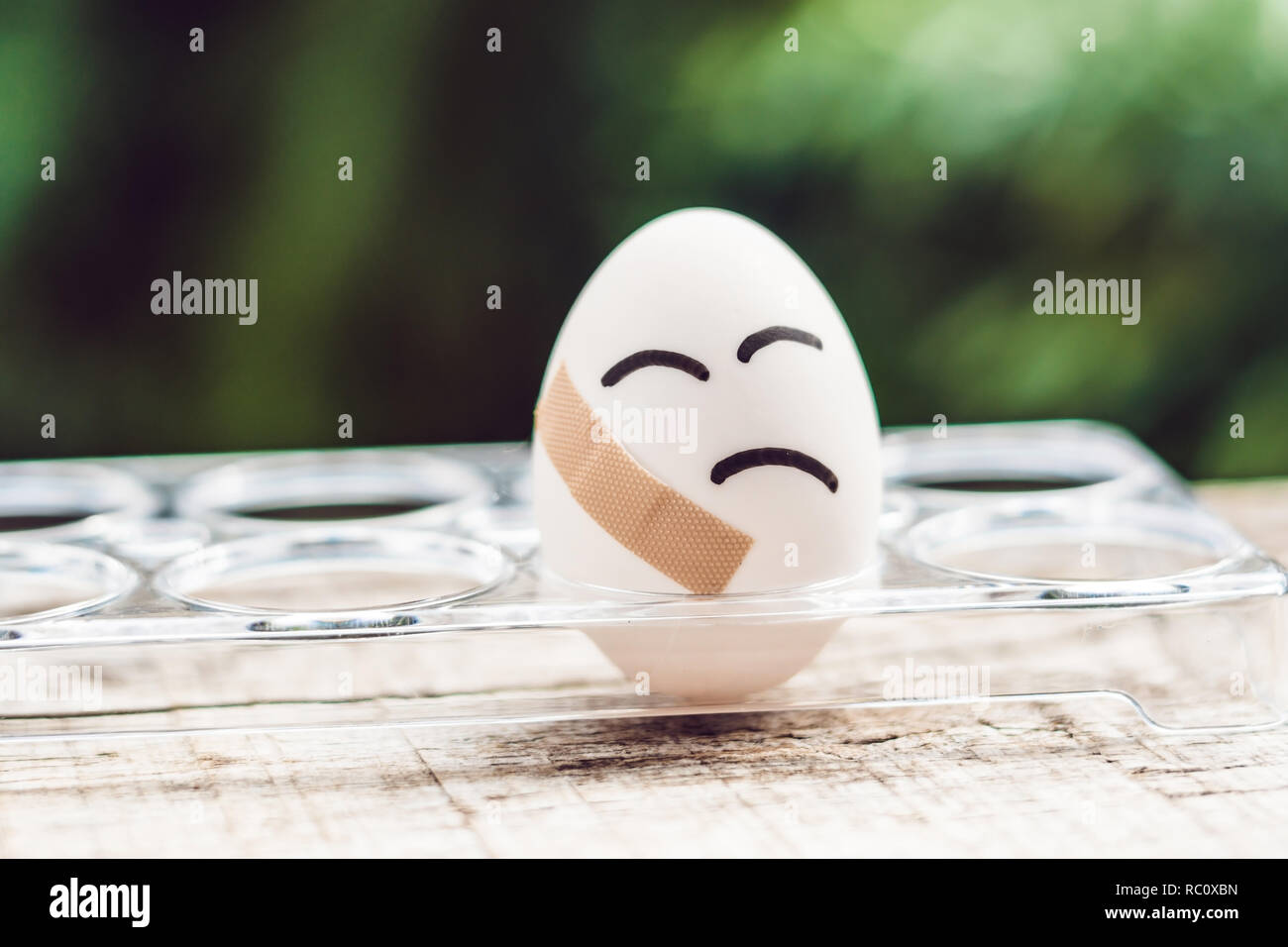 Broken egg with sticking plaster. Concept of brittleness and pain Stock ...