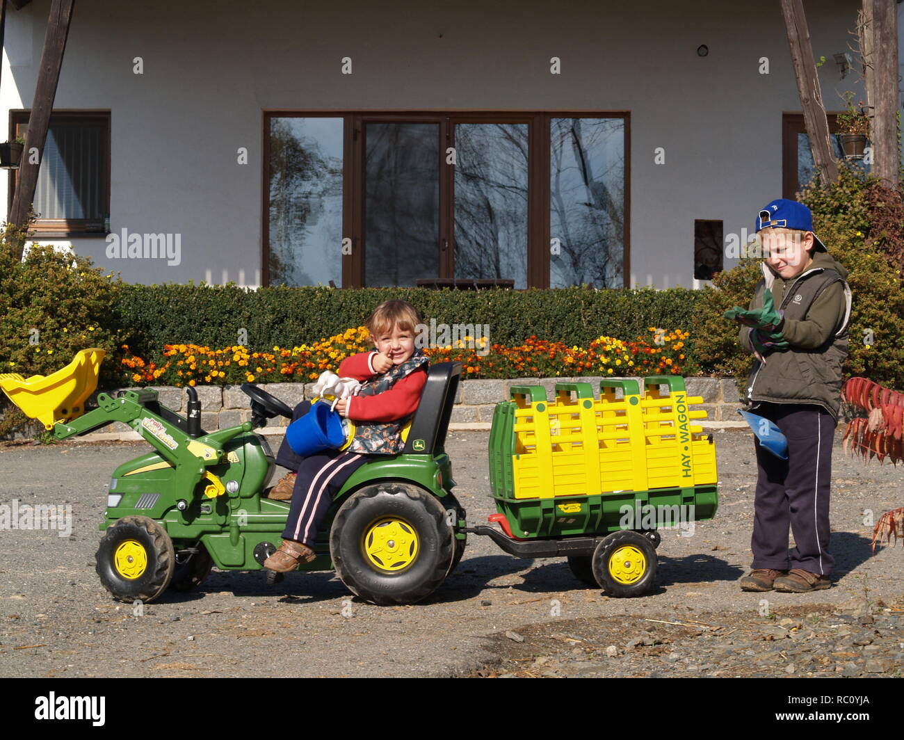 Boy and girl playing with toy tractor Stock Photo - Alamy