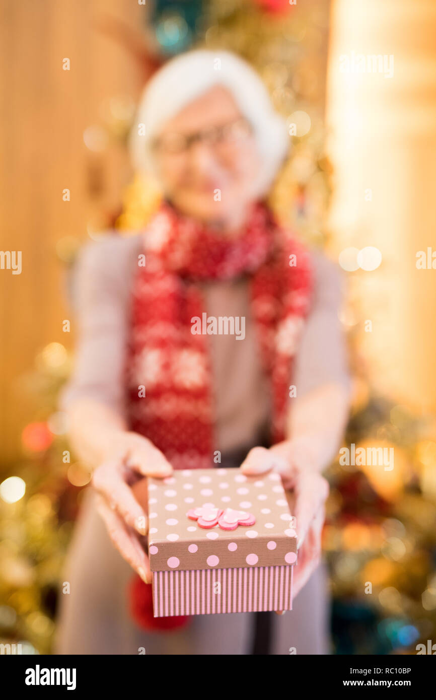 Senior lady giving gift in cute package with small hearts Stock Photo ...