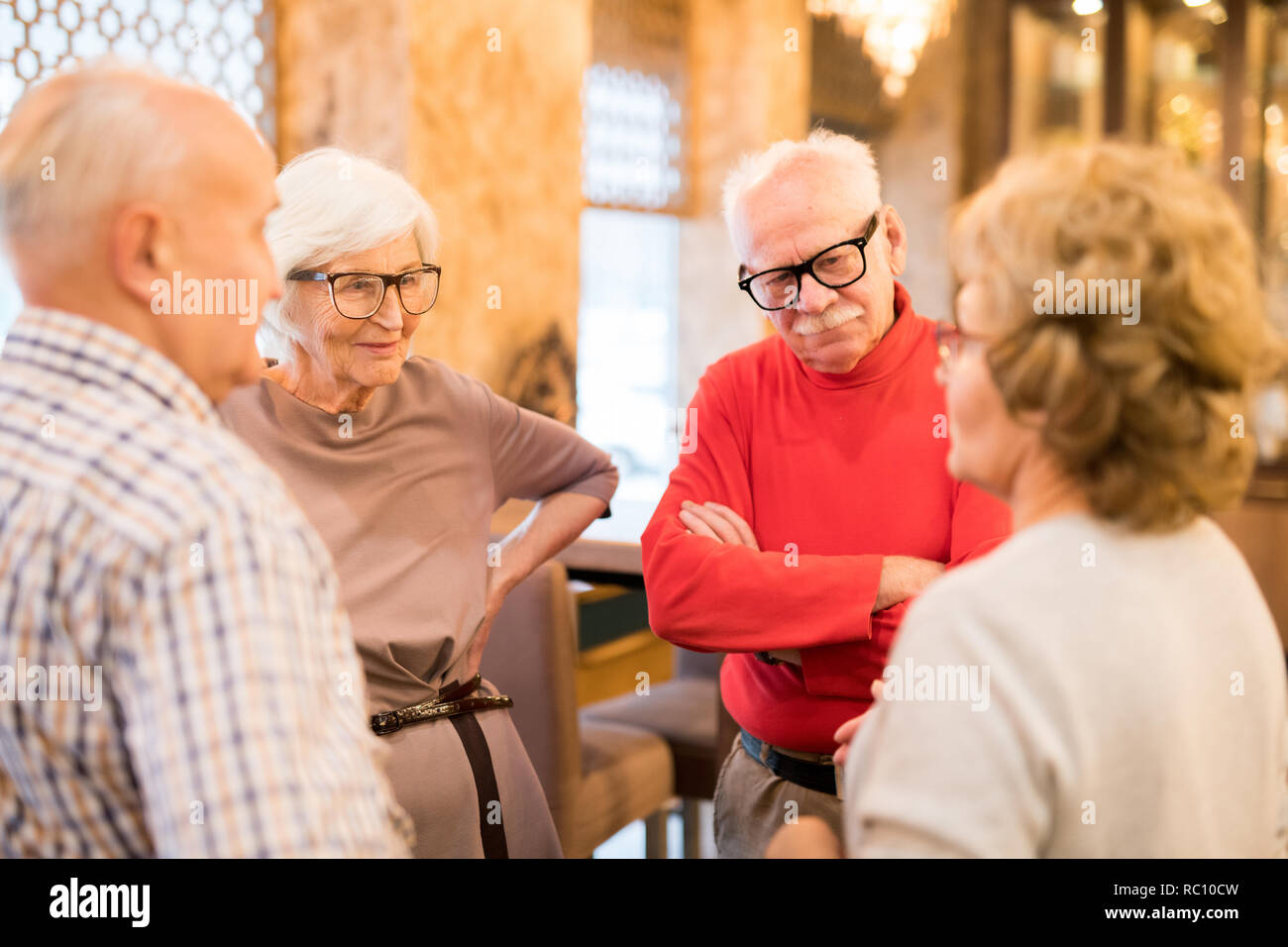 Group of seniors standing in circle and chatting Stock Photo - Alamy
