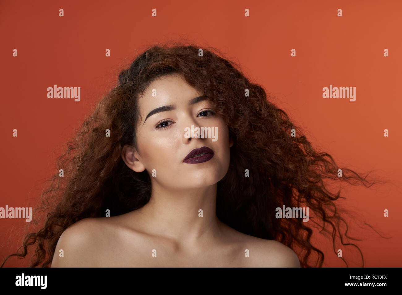 Portrait of latin girl isolated on orange color background Stock Photo ...