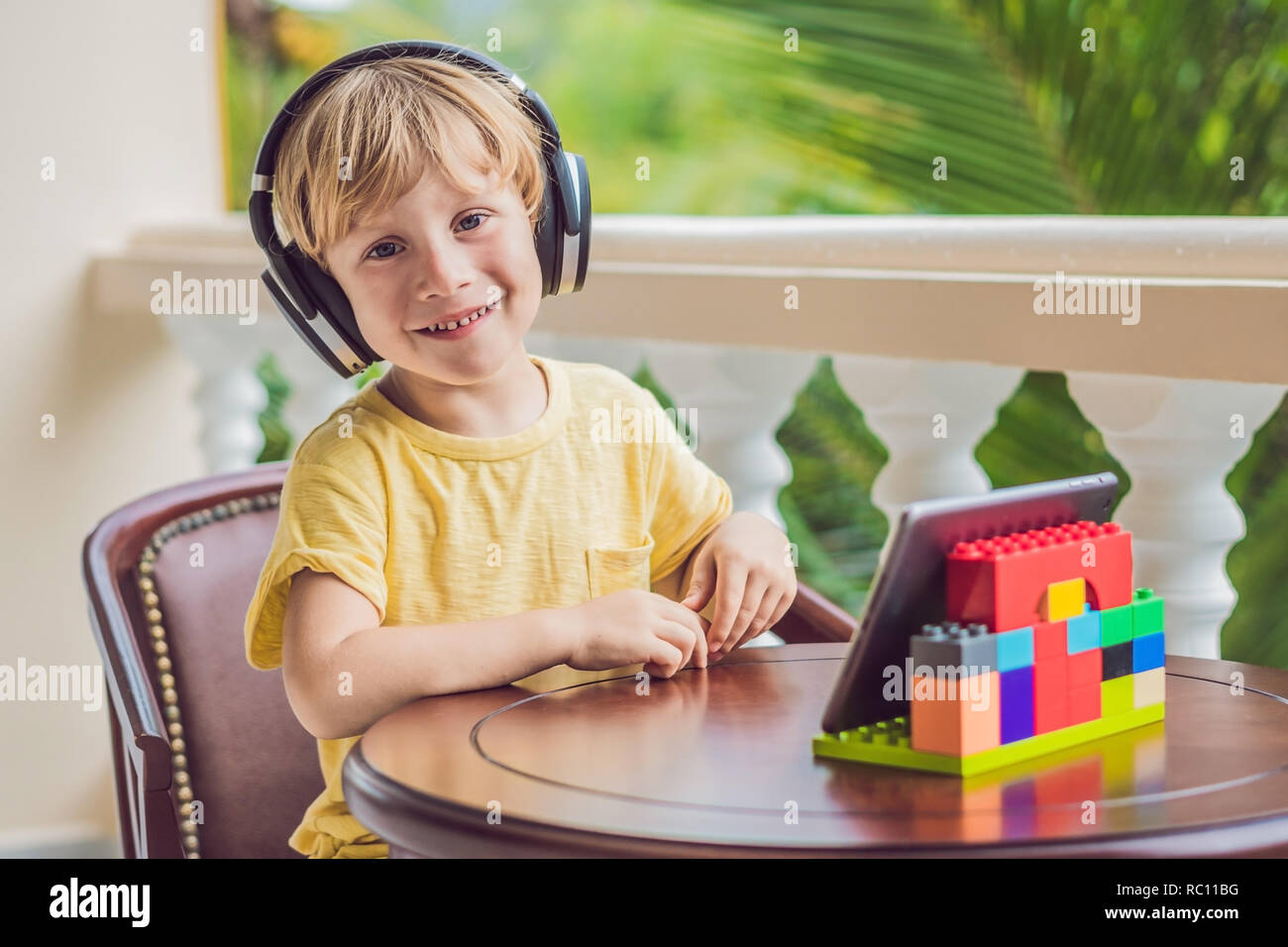 cute boy in the tropics talking with friends and family on video call ...