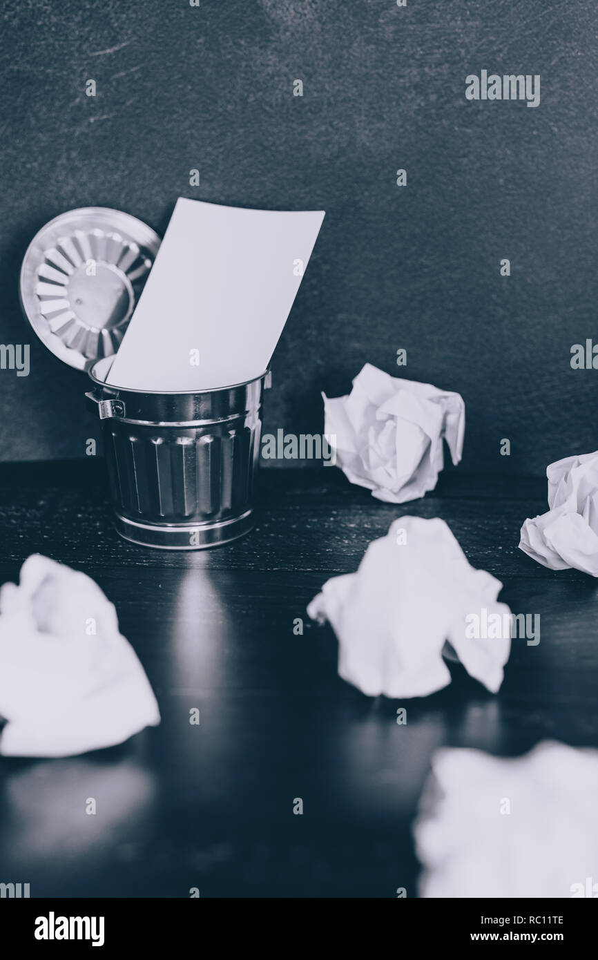 garbage bin on desk setting with empty notepad and scrunched paper ...