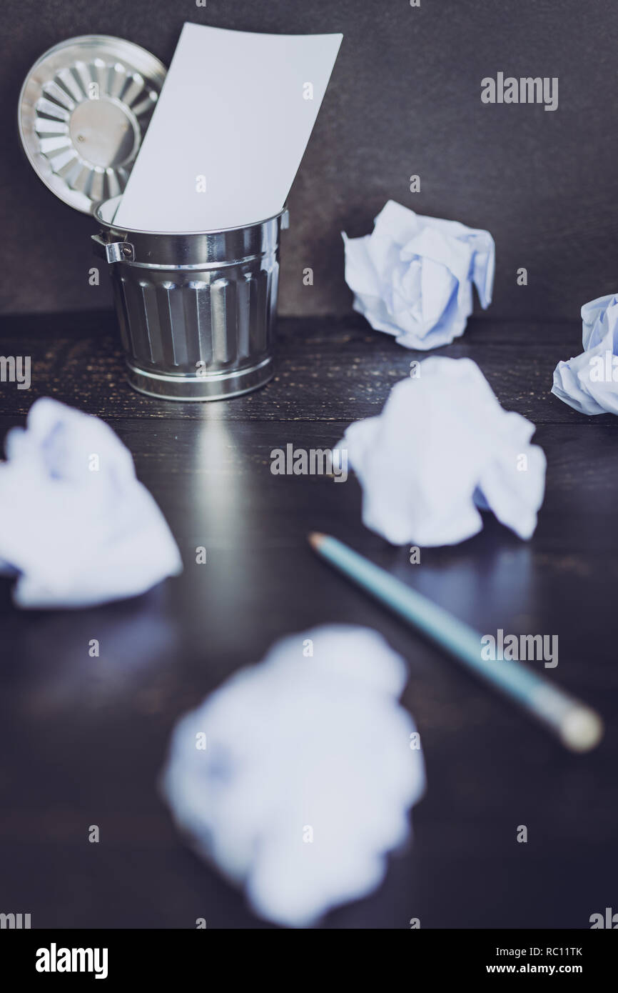garbage bin on desk setting with empty notepad and scrunched paper ...