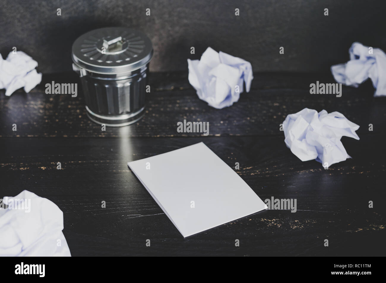 garbage bin on desk setting with empty notepad and scrunched paper ...