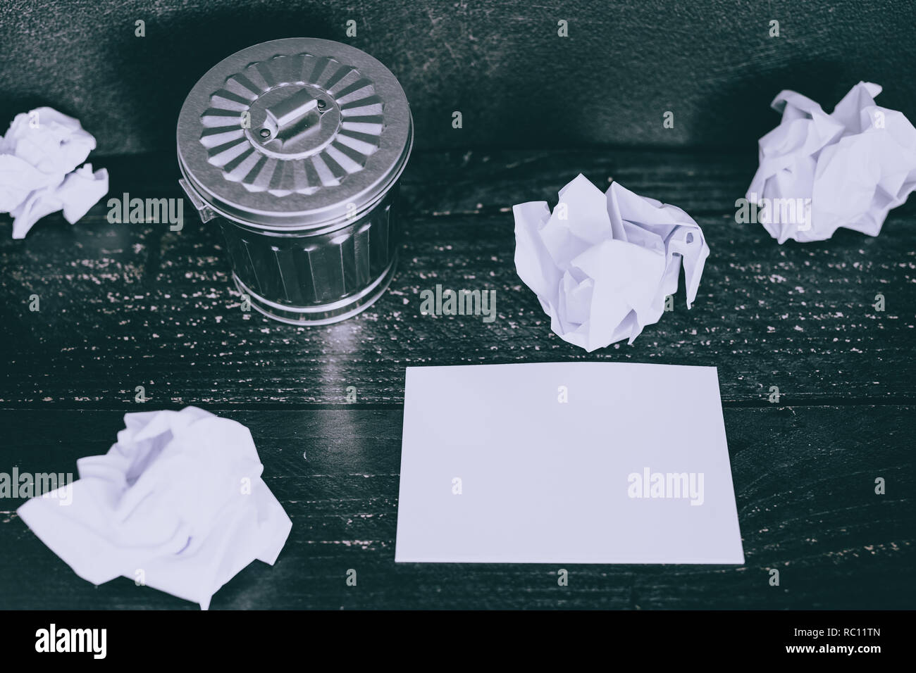garbage bin on desk setting with empty notepad and scrunched paper ...