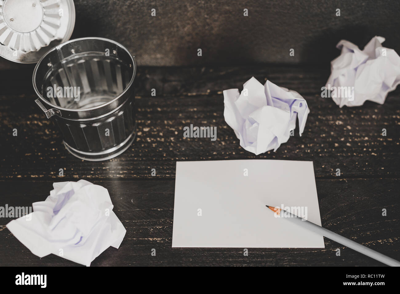 garbage bin on desk setting with empty notepad and scrunched paper ...
