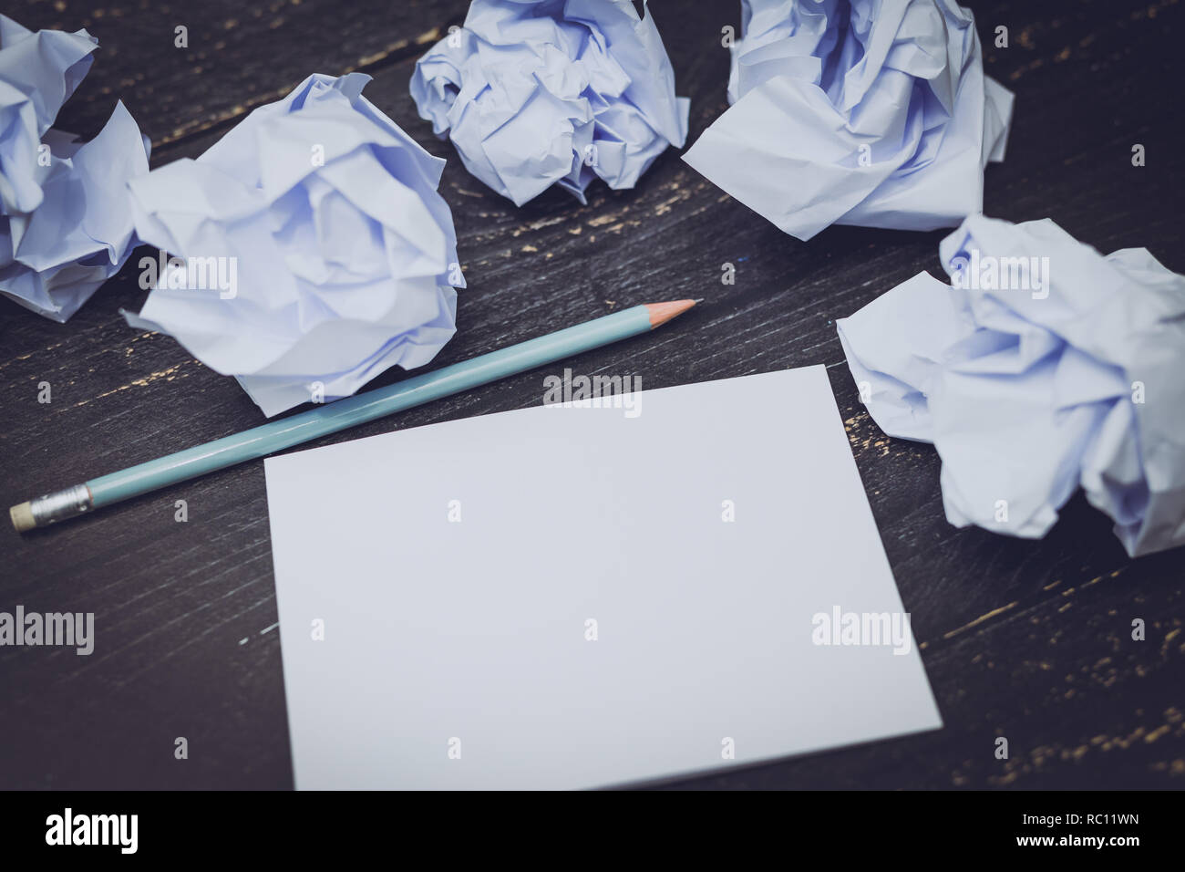 pencil on desk with notepad and scrunched paper balls, concept of ...