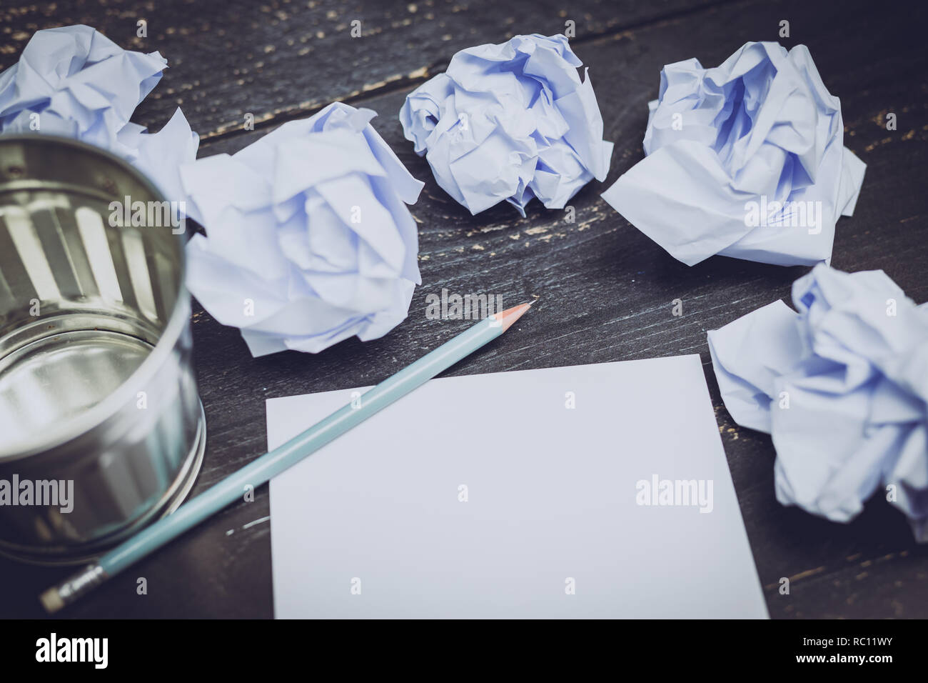 garbage bin on desk setting with pencil notepad and scrunched paper ...