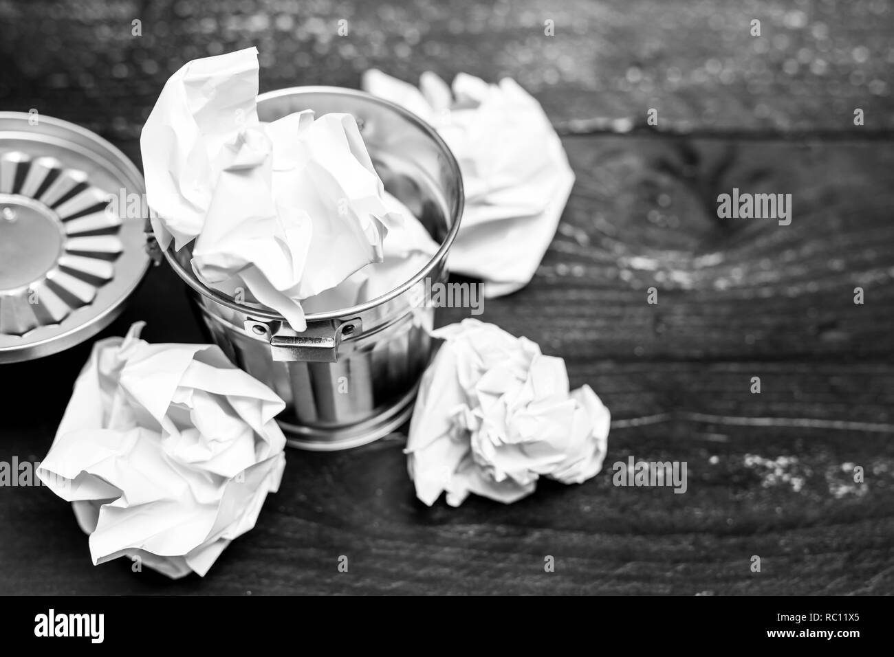 garbage bin on desk setting with scrunched paper balls inside, concept ...