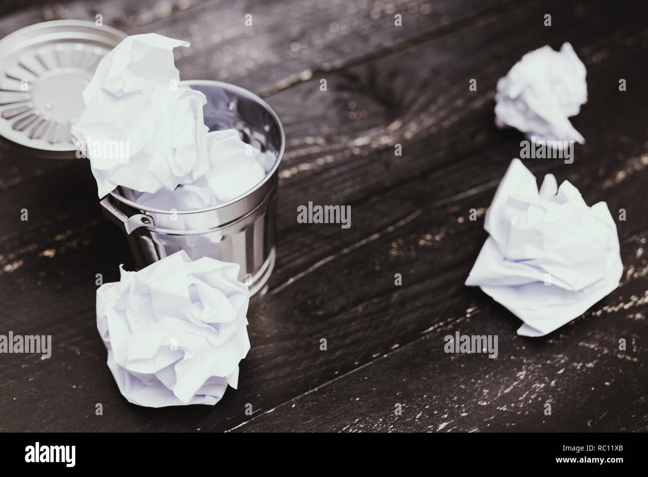 garbage bin on desk setting with scrunched paper balls inside, concept ...