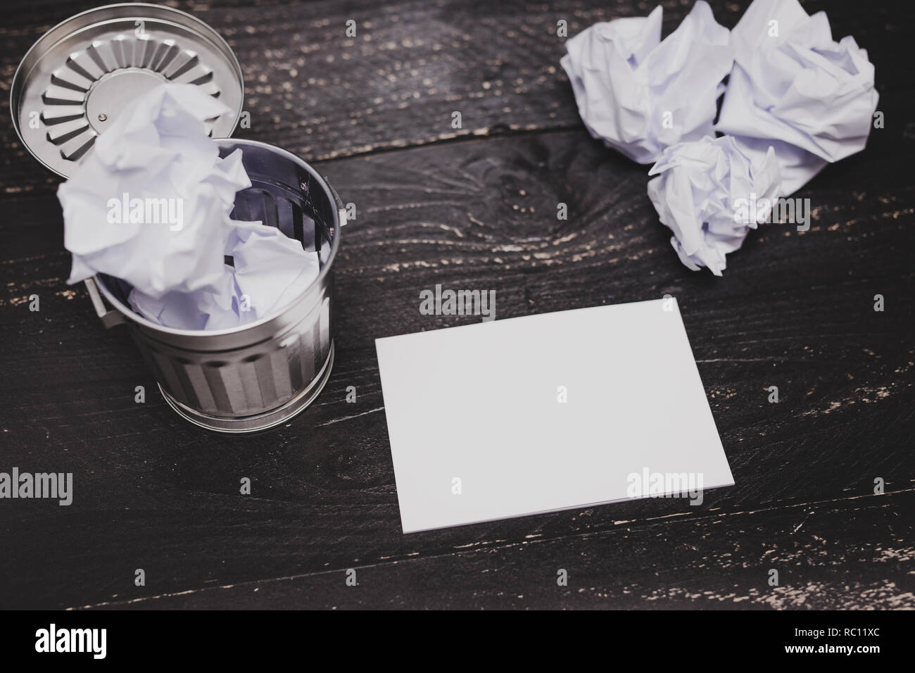 garbage bin on desk setting with pencil notepad and scrunched paper ...