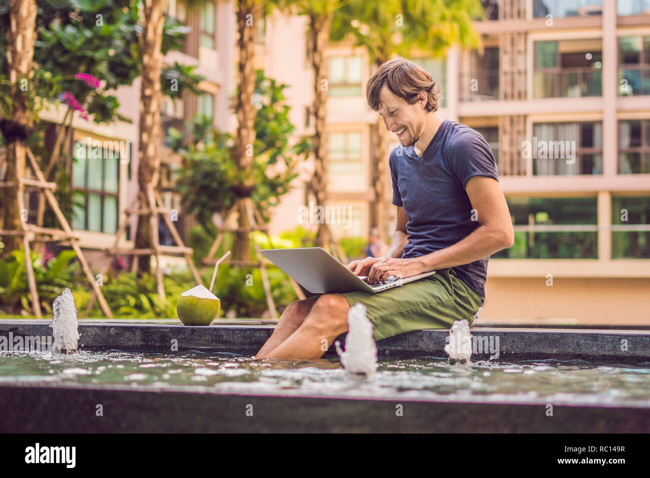 Young freelancer working on vacation next to the swimming pool Stock ...