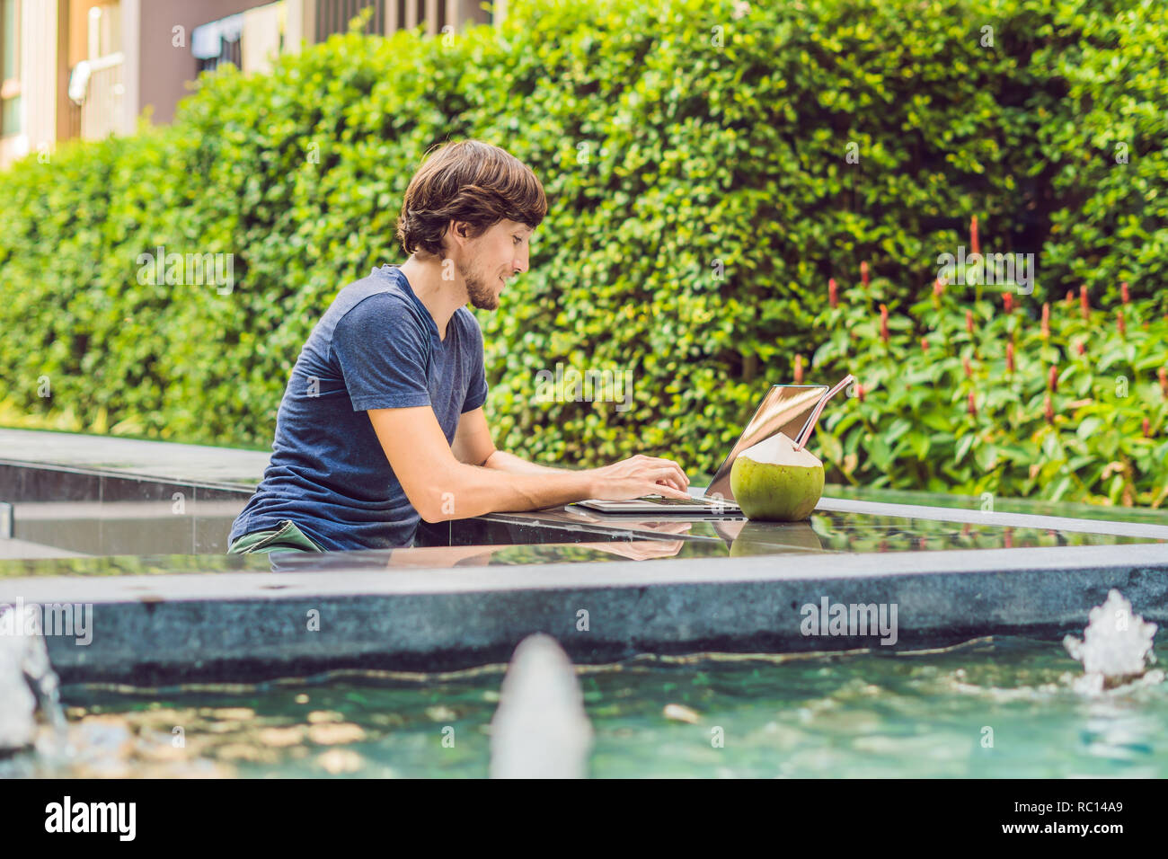 Young freelancer working on vacation next to the swimming pool Stock ...