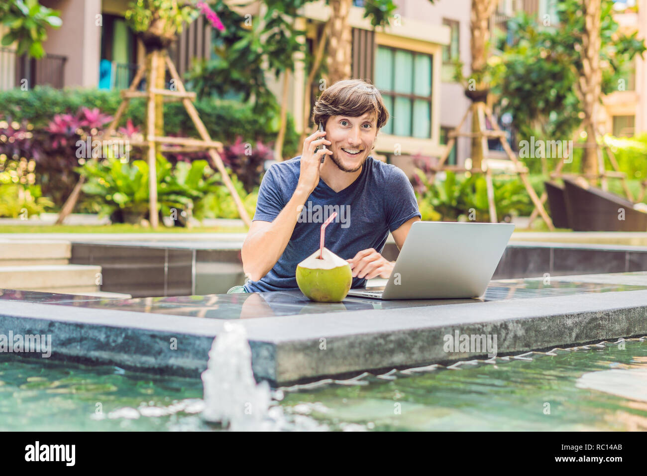 Young freelancer working on vacation next to the swimming pool Stock ...