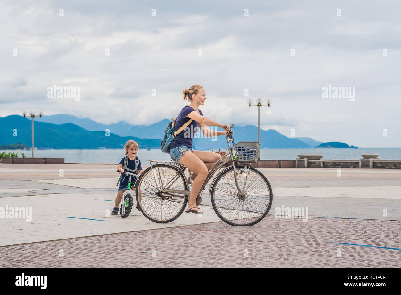 Happy family is riding bikes outdoors and smiling. Mom on a bike and ...