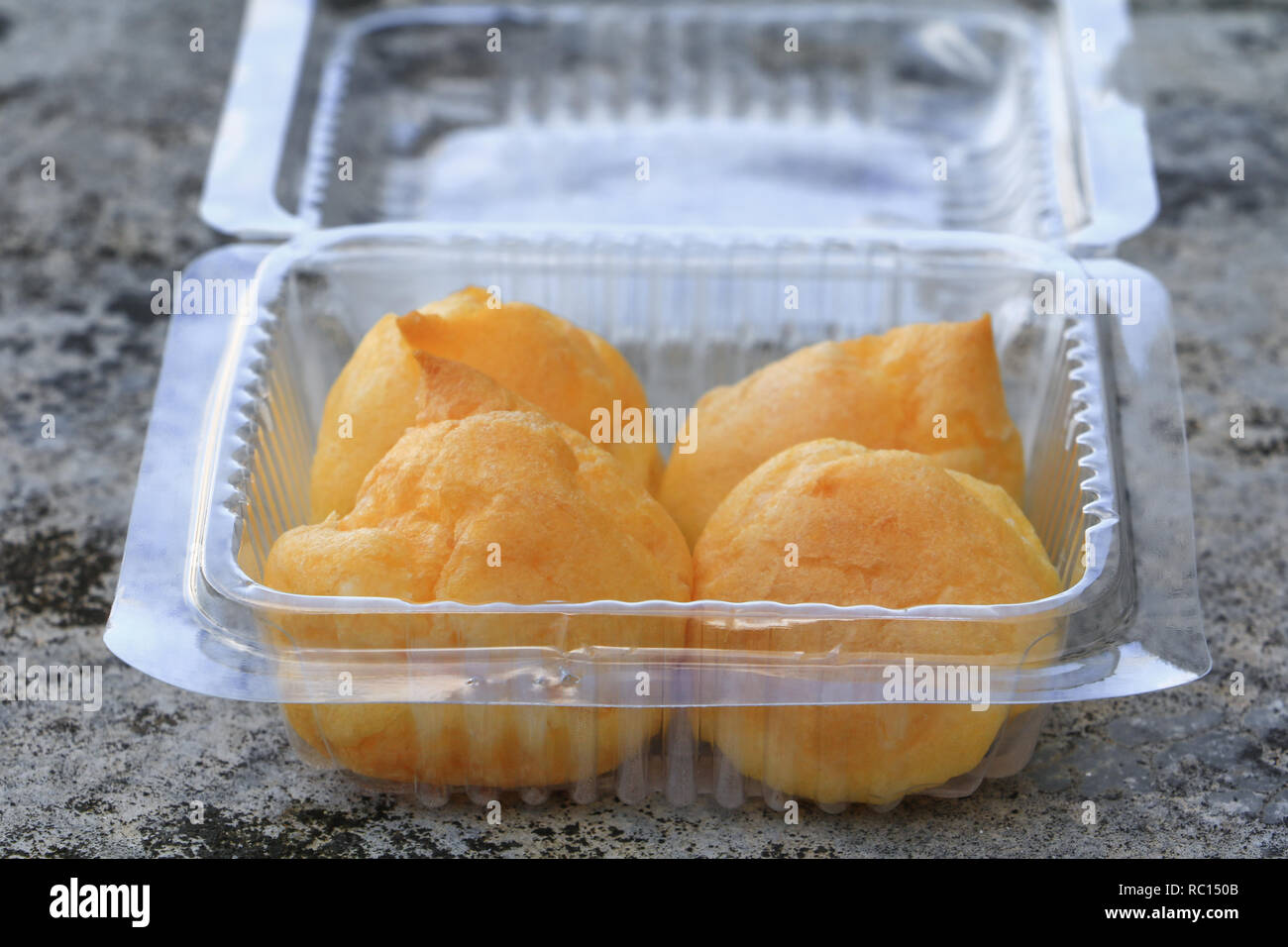 close up cream puffs in box plastic on the cement floor old with copy ...