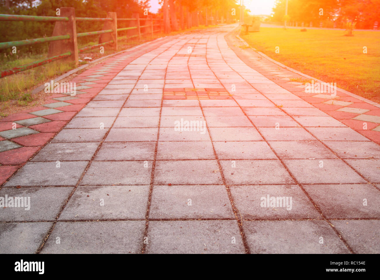 Stone block walk path in public park with sunset light tone: Select ...