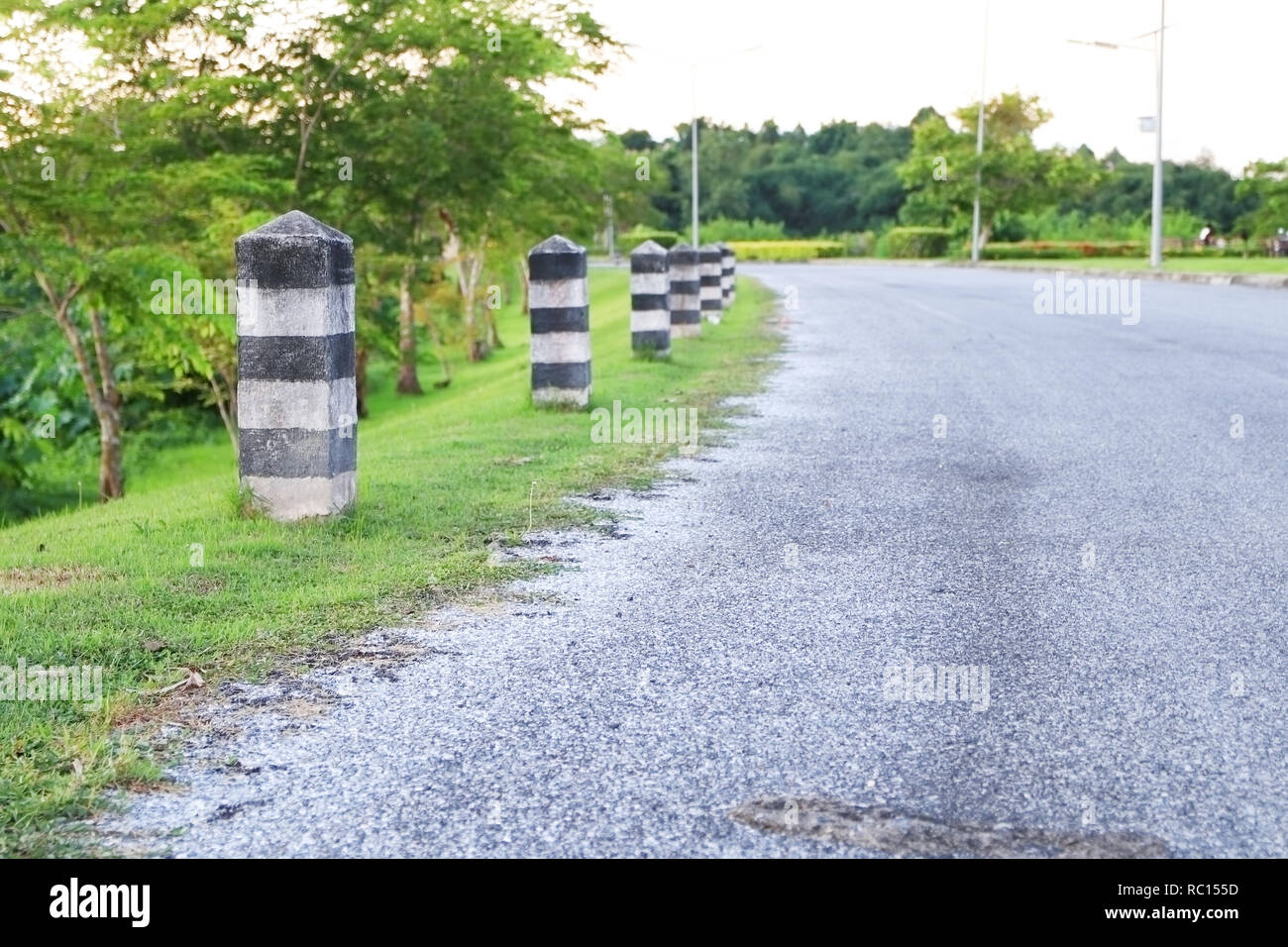 black and white painted milestone. in range roadside on white ...