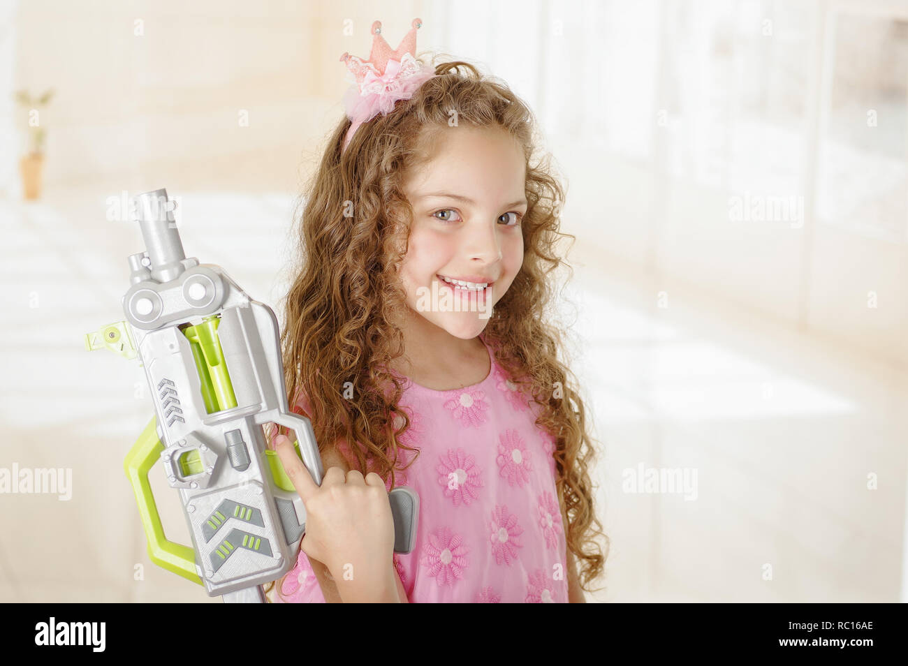 Happy little girl with gun and wearing a pink princess dress Stock ...
